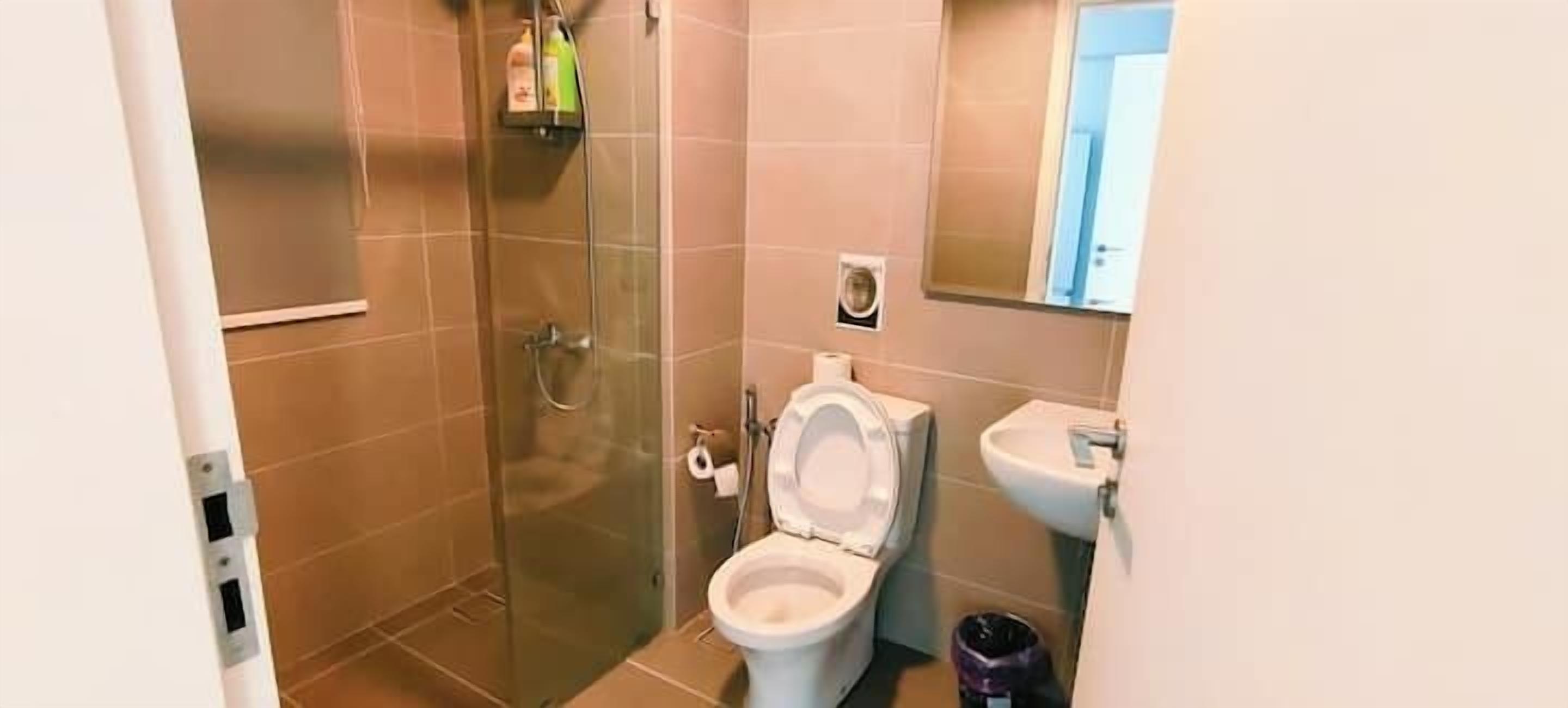 Uma casa de banho com cabine de duche em vidro, sanita e lavatório.