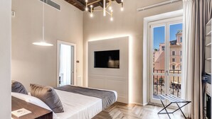 Quarto moderno com cama, mesa de cabeceira e televisão na parede.