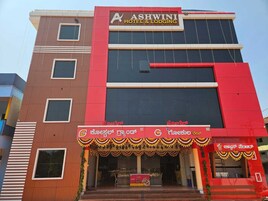 Um edifício de vários andares com uma placa grande do Ashwini Hotel & Lodging.