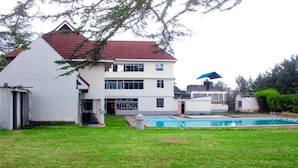 Uma casa de dois andares com piscina no quintal.