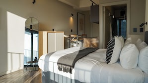 Quarto moderno com cama grande, ventilador de teto e vista para o exterior.