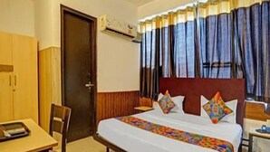 Quarto de hotel com uma cama, uma mesa, uma cadeira e um guarda-roupa.
