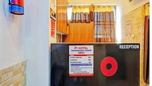 Uma área de recepção com uma placa indicando 'Vasundhara Grand Tariff' e um logotipo circular vermelho.