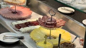 Buffet com diversos alimentos expostos em recipientes de vidro.