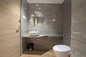 Um polibã e uma banheira separados, um secador de cabelo, chinelos 