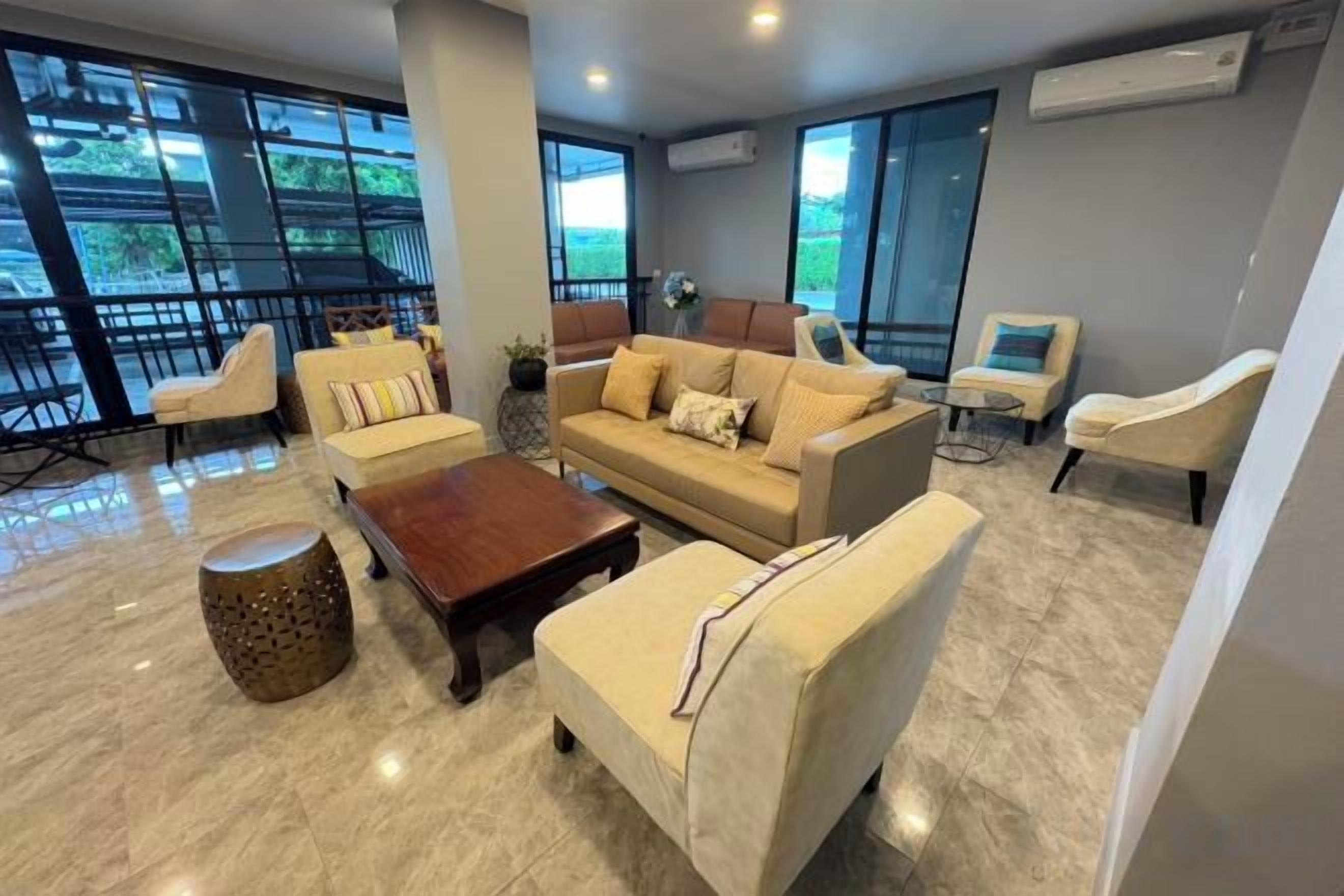 Uma sala de estar moderna com sofá, mesa de centro e um banquinho estampado.