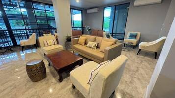 Uma sala de estar moderna com sofá, mesa de centro e um banquinho estampado.