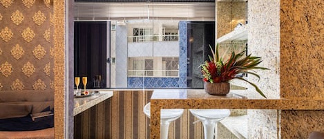 Uma cozinha moderna com bancada de mármore, dois banquetes e um vaso de planta.