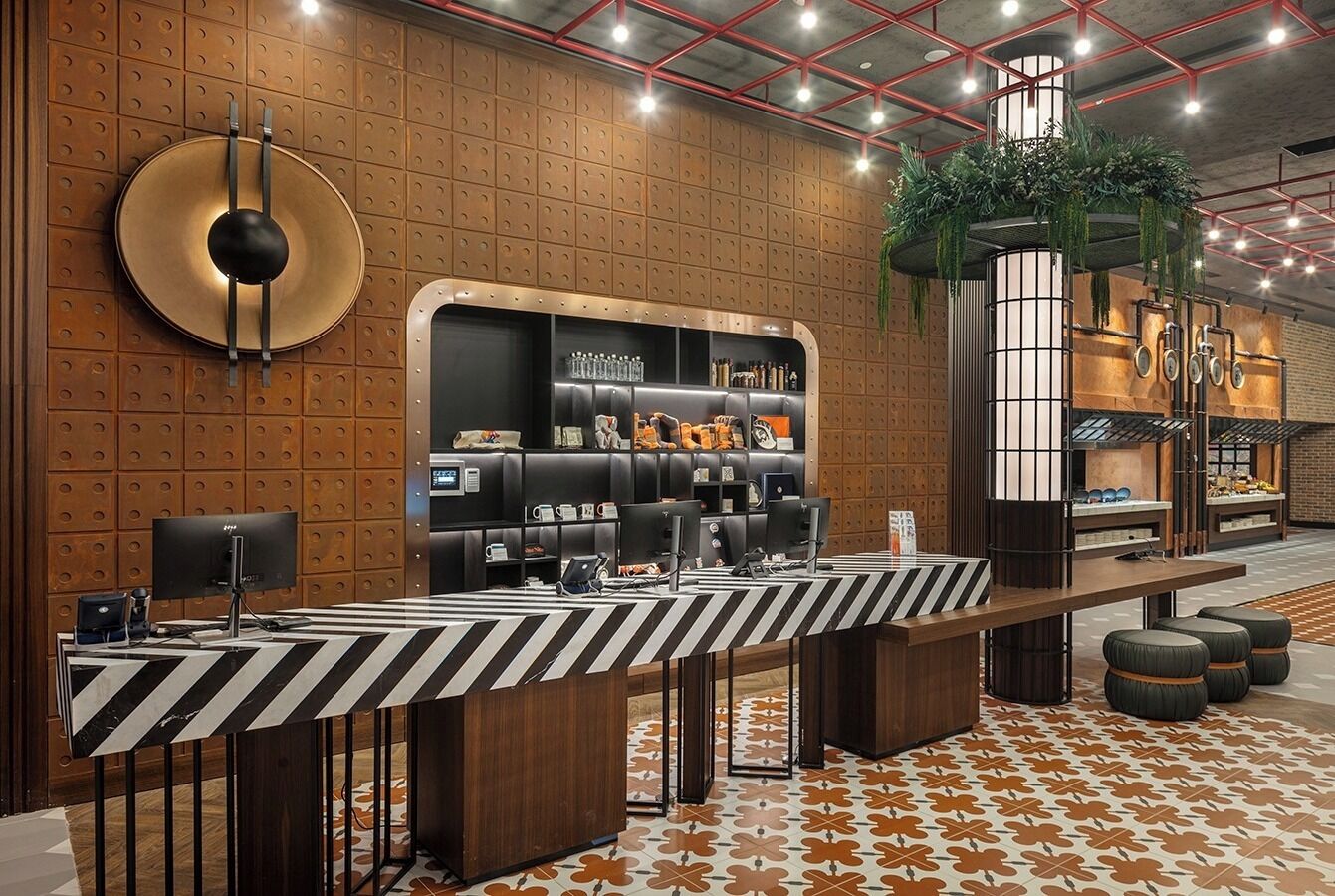 Uma área de bar moderna com um balcão comprido, diversas opções de assento e uma parede decorativa com design circular.