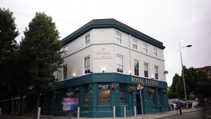 Um edifício de esquina com o nome 'ROYAL ALFRED' na fachada.