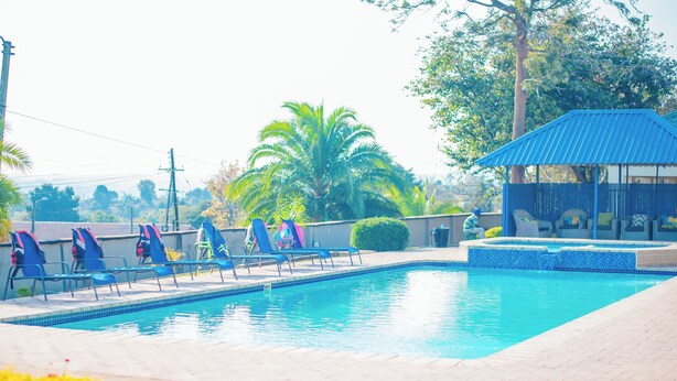 Piscina com espreguiçadeiras e área de estar coberta.