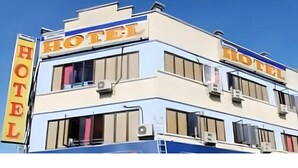 Um hotel de vários andares com um grande letreiro 'HOTEL' na fachada.