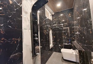 Quarto Triplo Deluxe | Casa de banho | Um polibã, um chuveiro fixo, artigos de higiene pessoal grátis 