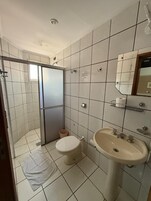 Chuveiro, toalhas de banho, sabonete, papel higiênico