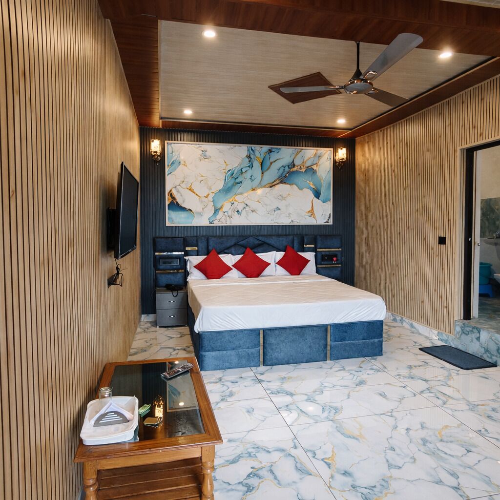 Quarto moderno com uma cama grande, um ventilador de teto, uma TV e piso de mármore.
