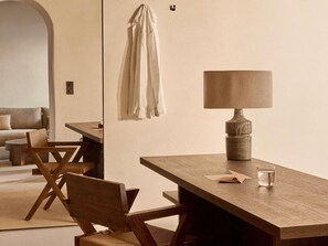 Quarto minimalista com uma mesa de madeira, uma luminária e uma cadeira.