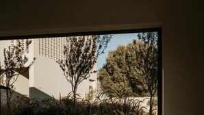 Um interior moderno com uma grande janela, piso em azulejo e design minimalista.