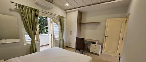 Quarto com cama, escrivaninha, cadeira e guarda-roupa.
