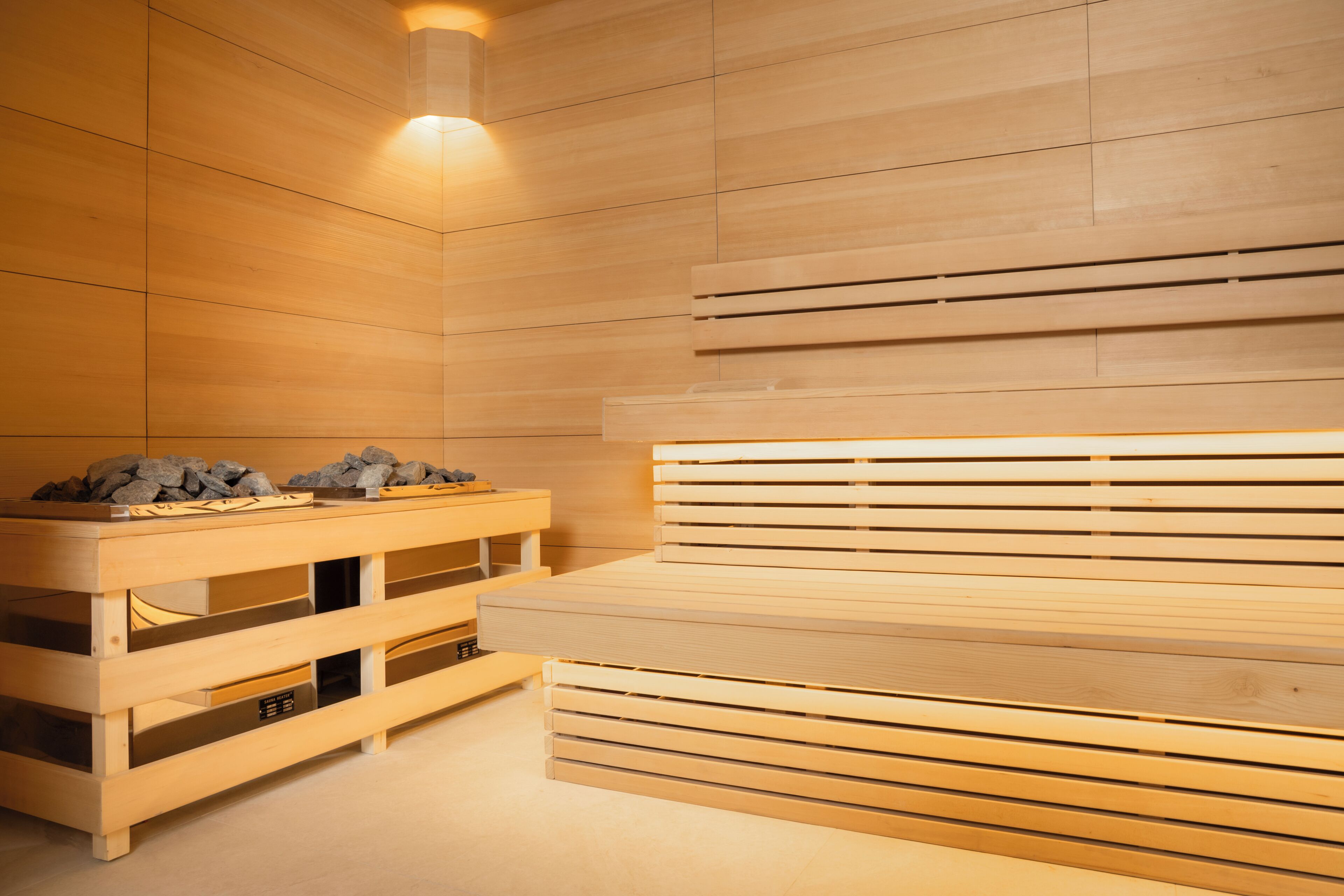Sala de sauna com bancos de madeira e um banco com aquecedor embutido.