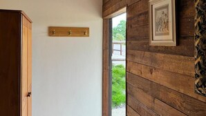 Parede de madeira com moldura de quadro e interruptor de luz.