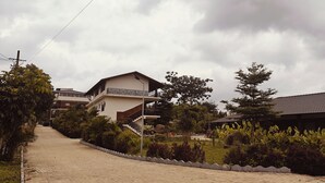 Uma área residencial com casas, uma rua pavimentada e um jardim.