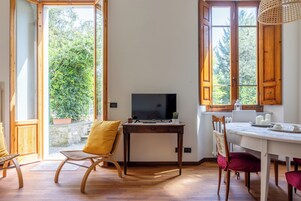 Apartamento, pátio, vista para o jardim | Sala de estar | Televisor de ecrã plano de 32 polegadas com canais por cabo