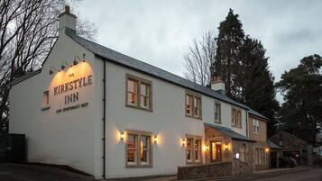 Um edifício branco com uma placa que diz 'The Kirkstyle Inn and Sportsman's Rest'.