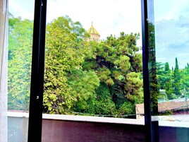 Vista pela janela de um edifício com estrutura em cúpula ao fundo.