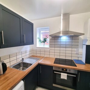 Um frigorífico, um micro-ondas, um forno, uma placa de cozinha 