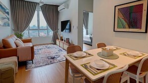 Uma sala de estar moderna com sofá, conjunto de mesa de jantar e vista para a cidade.