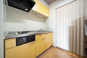 Um frigorífico, um micro-ondas, uma placa de cozinha, uma torradeira 