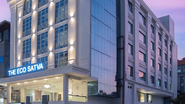 Um edifício de hotel moderno com uma placa que diz "HOTEL THE ECO SATVA".