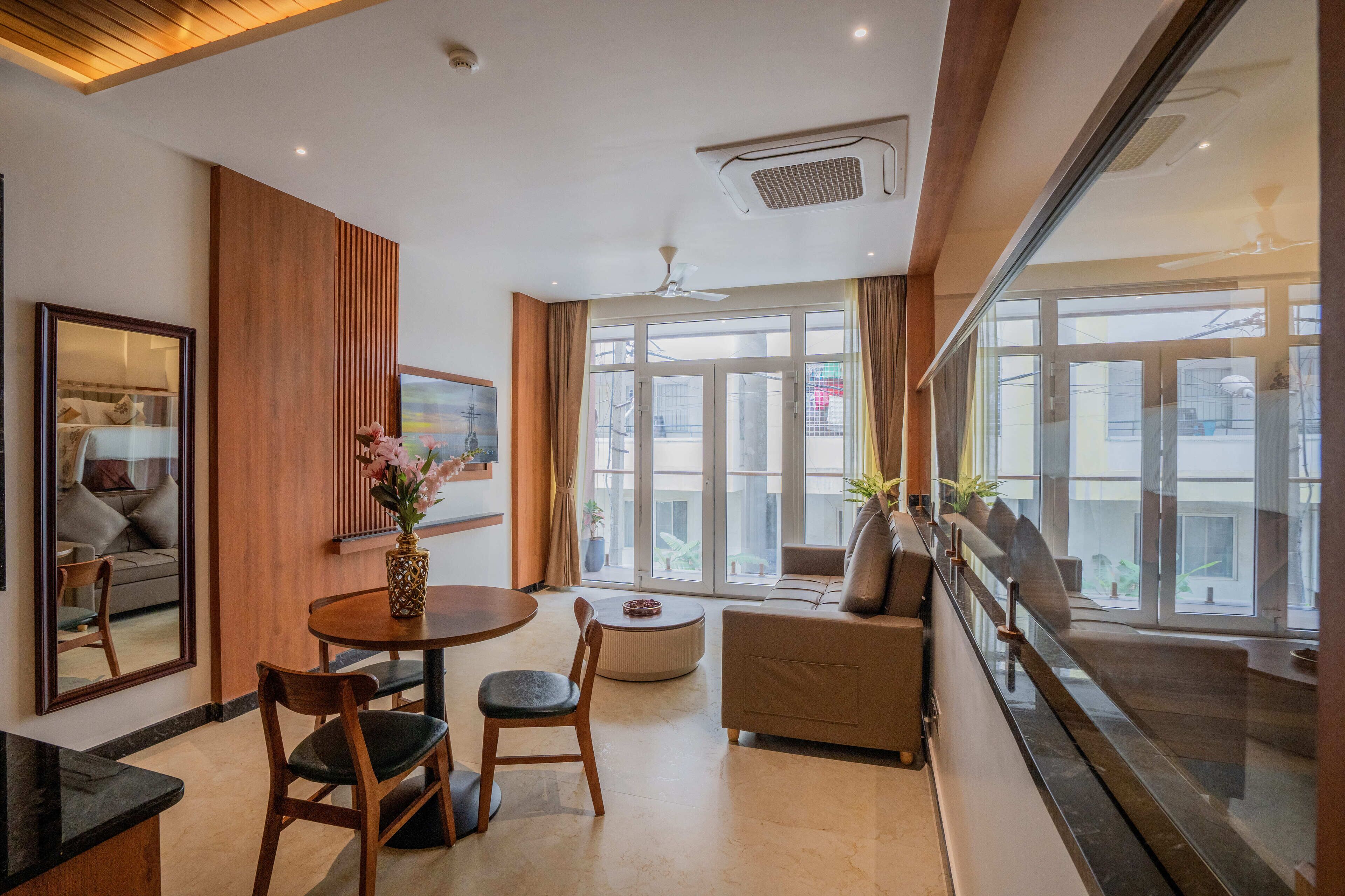 Uma sala de estar moderna com área de jantar, janelas amplas e vista da cidade.