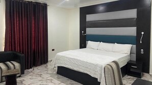 Quarto moderno com uma cama, uma cadeira e uma mesa de cabeceira.