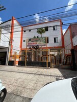 Edifício com placa indicando 'Pousada Freitas' e portão de entrada.