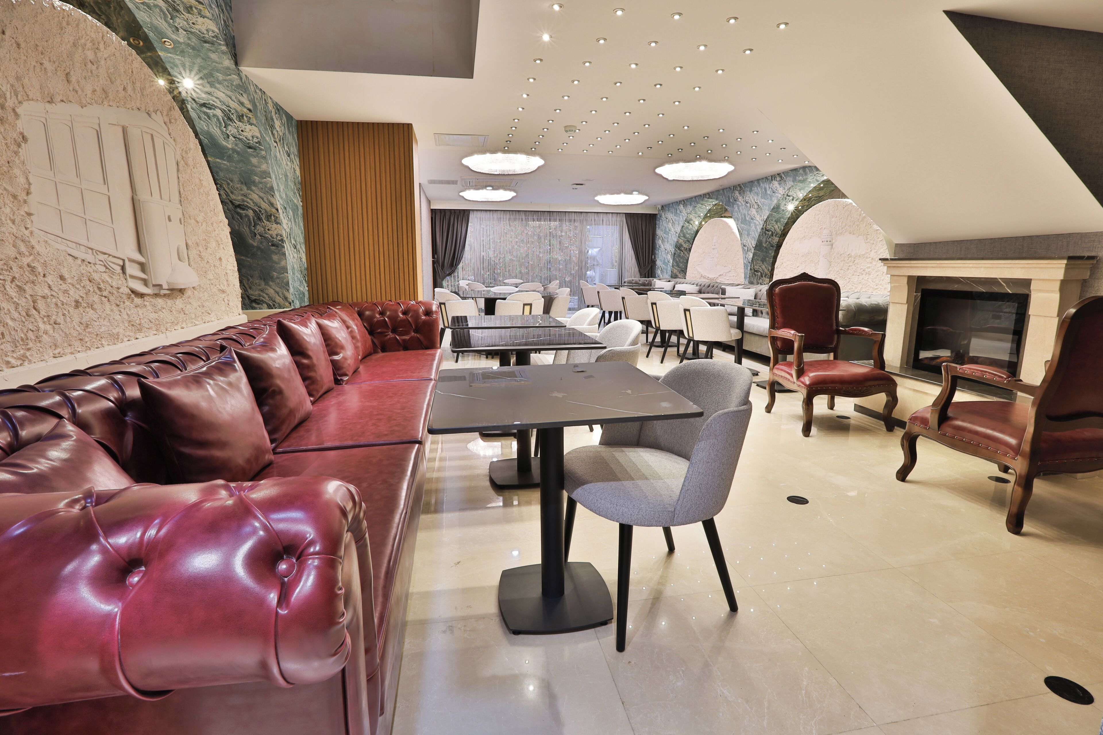 Um restaurante moderno com assentos de couro, lareira e parede de mármore.