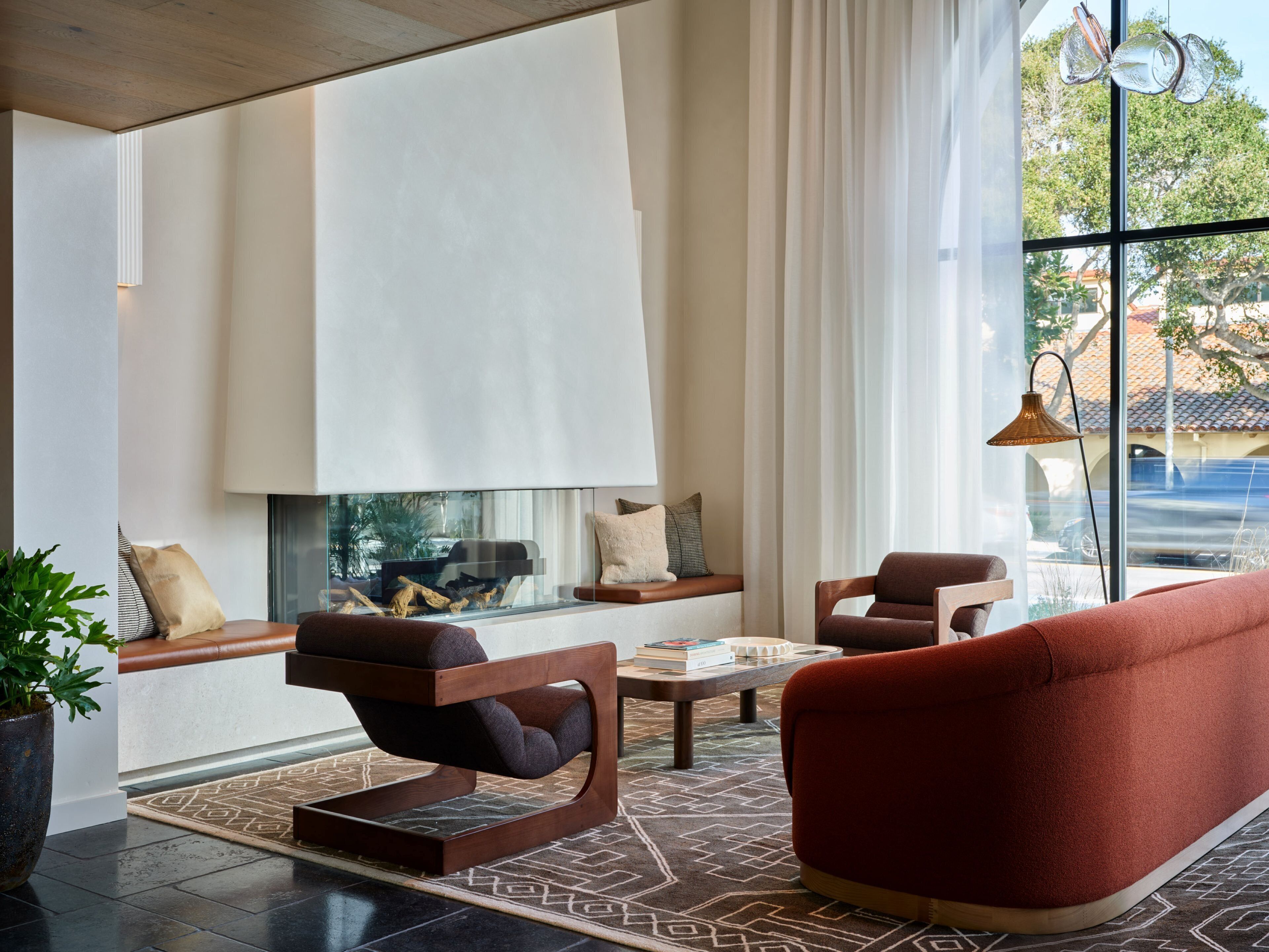 Uma sala de estar moderna com sofá, poltronas, mesa de centro e lareira.