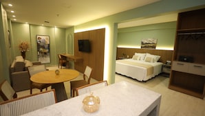 Quarto de hotel com uma cama, uma escrivaninha, uma mesa de jantar e uma área de estar.