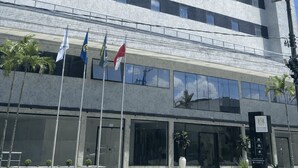 Um edifício alto e moderno, com fachada de vidro e várias janelas.