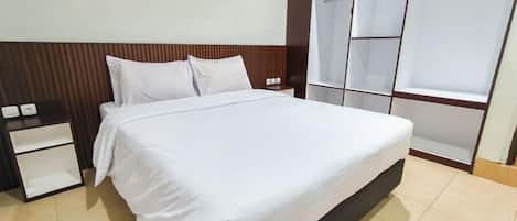 Quarto com cama, mesa de cabeceira e armário embutido.