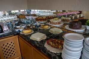 Um buffet com diversos doces e bebidas.