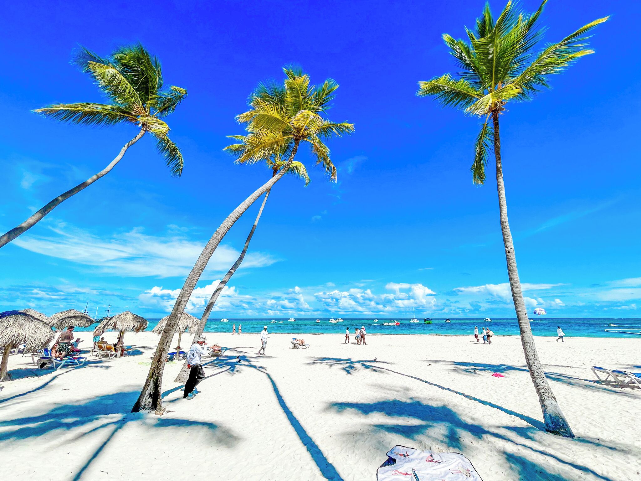 Na praia, praia de areia branca, espreguiçadeiras, guarda-sóis de praia 