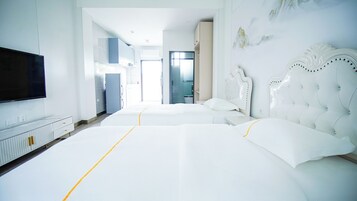 Quarto de hotel com duas camas, televisão e banheiro visível por uma porta aberta.