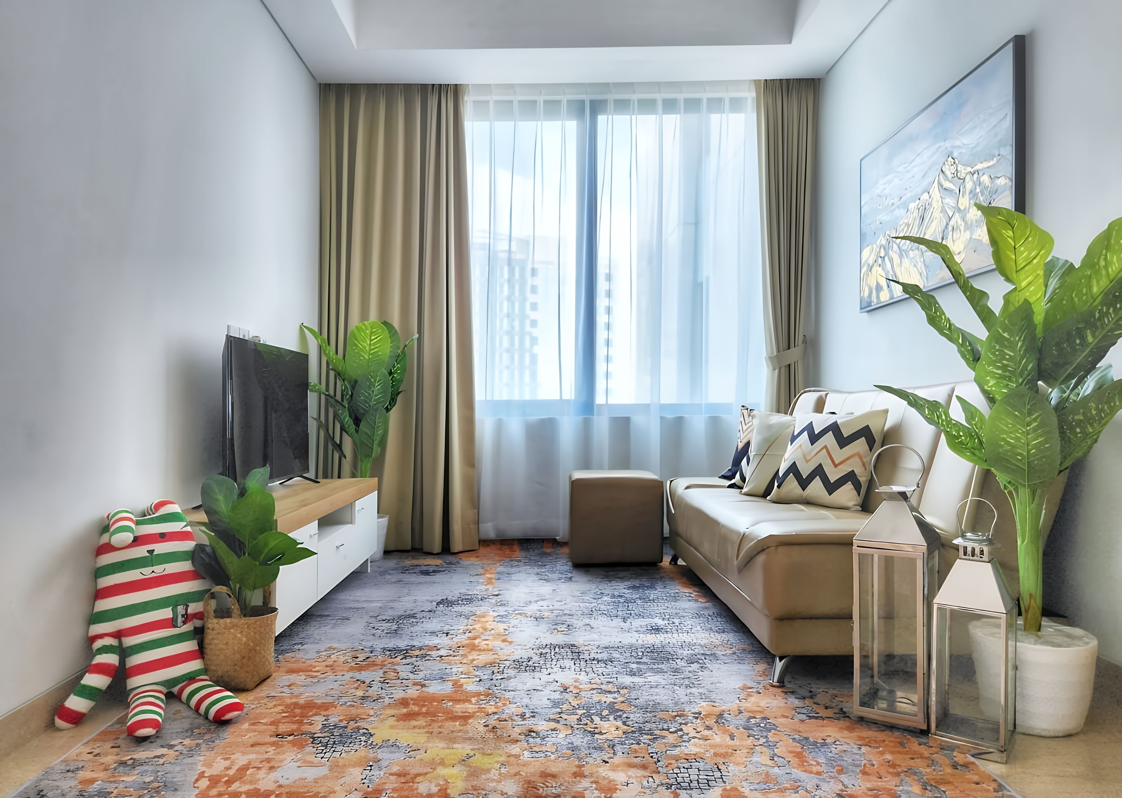 Uma sala de estar moderna com um sofá, uma televisão, um tapete estampado e plantas verdes grandes.