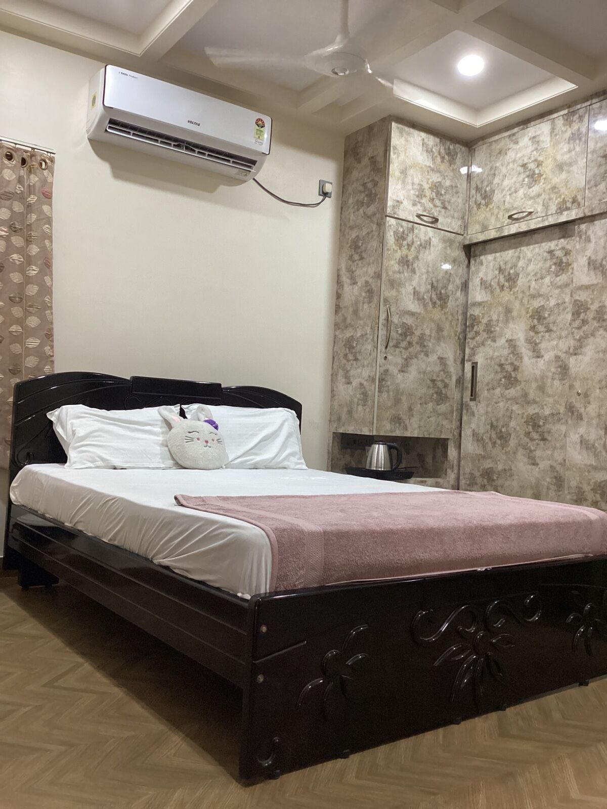 Quarto com cama, ar-condicionado, guarda-roupa e cafeteira.
