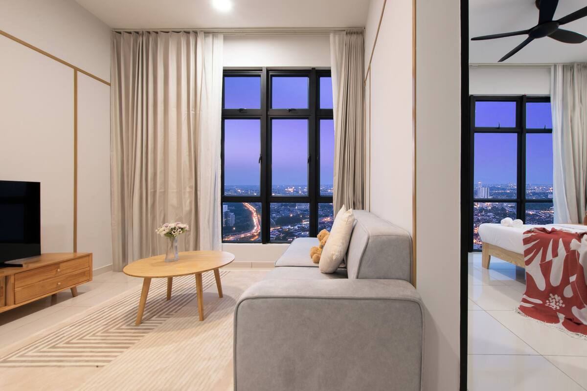 Uma sala de estar moderna com um sofá, uma mesa de centro e uma televisão.