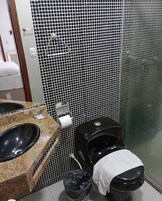 Chuveiro, toalhas de banho, sabonete, papel higiênico