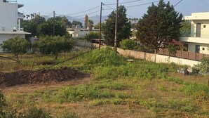 Zona residencial com edifícios modernos, céu claro e vegetação variada.