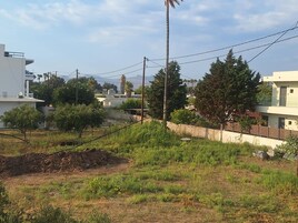 Zona residencial com edifícios modernos, céu claro e vegetação variada.