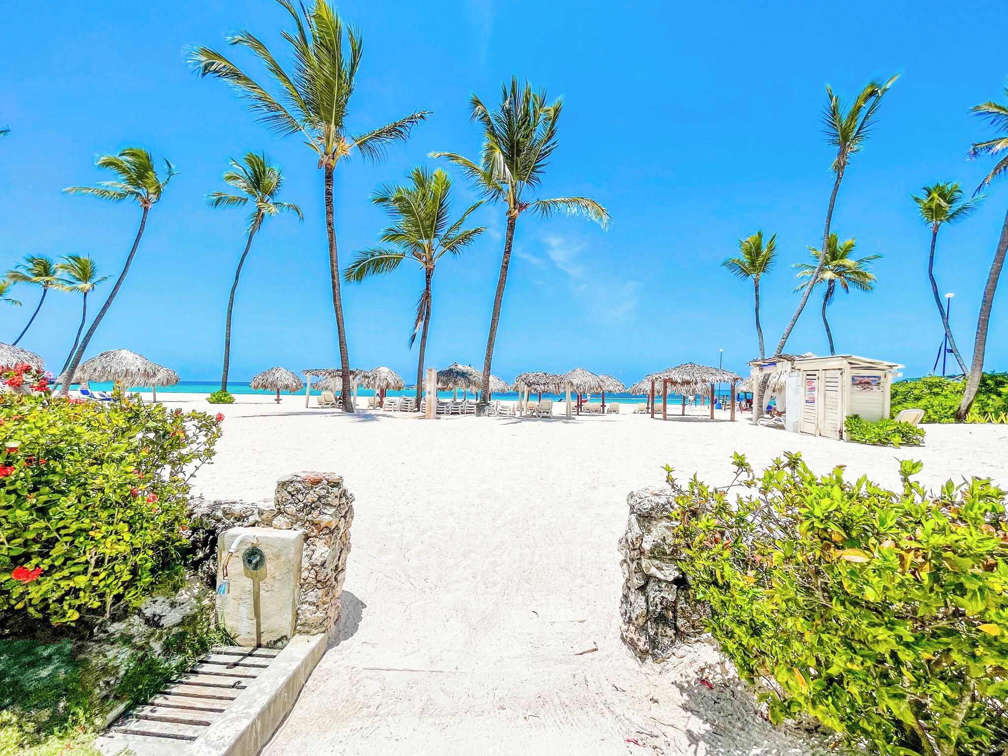 Na praia, praia de areia branca, espreguiçadeiras, guarda-sóis de praia 